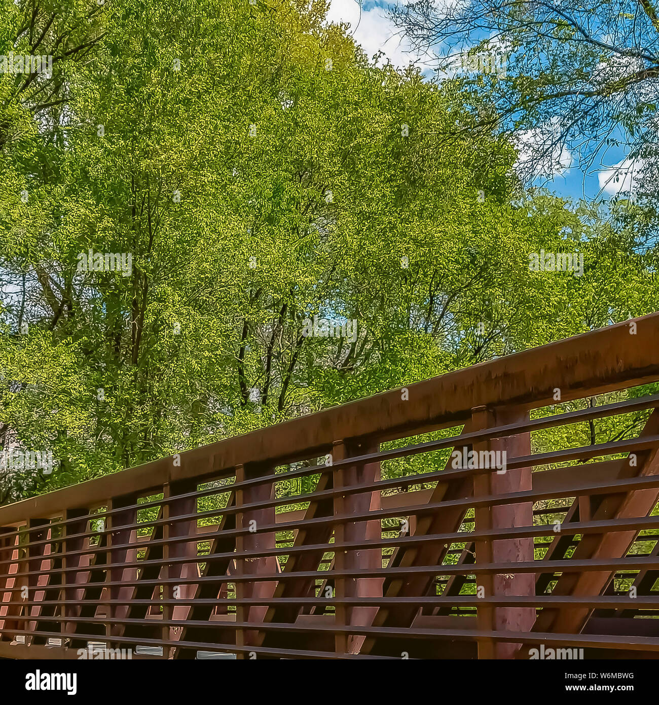 Square frame Bridge with latticed metal guardrail over a calm stream ...