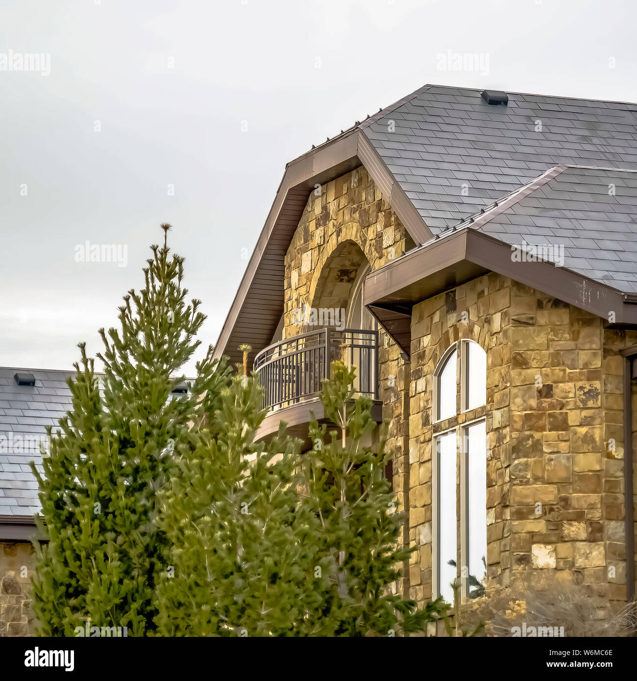 Square frame Stone home with half circle balcony and quarter round with ...