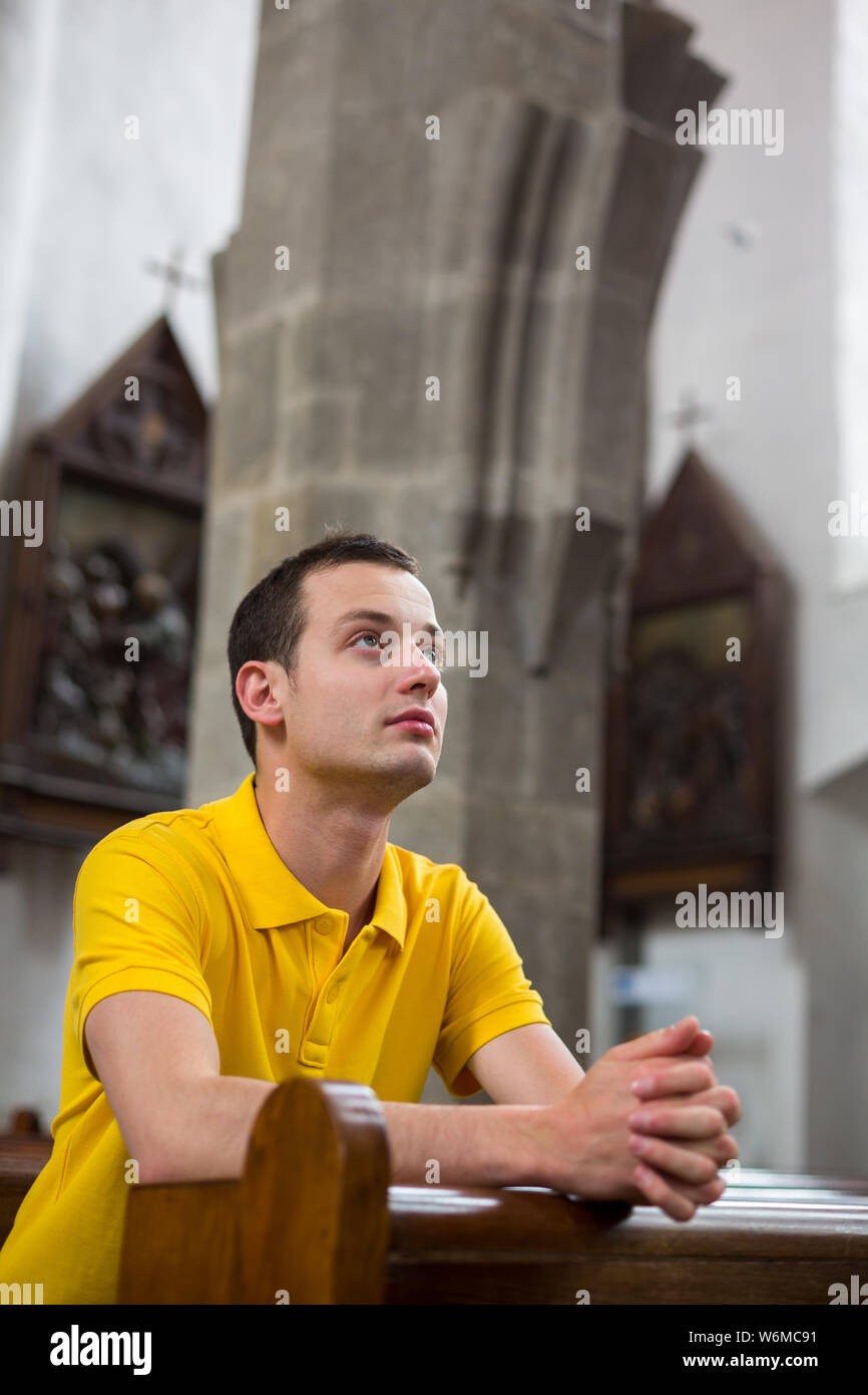 Handsome young man praying in a church Stock Photo - Alamy