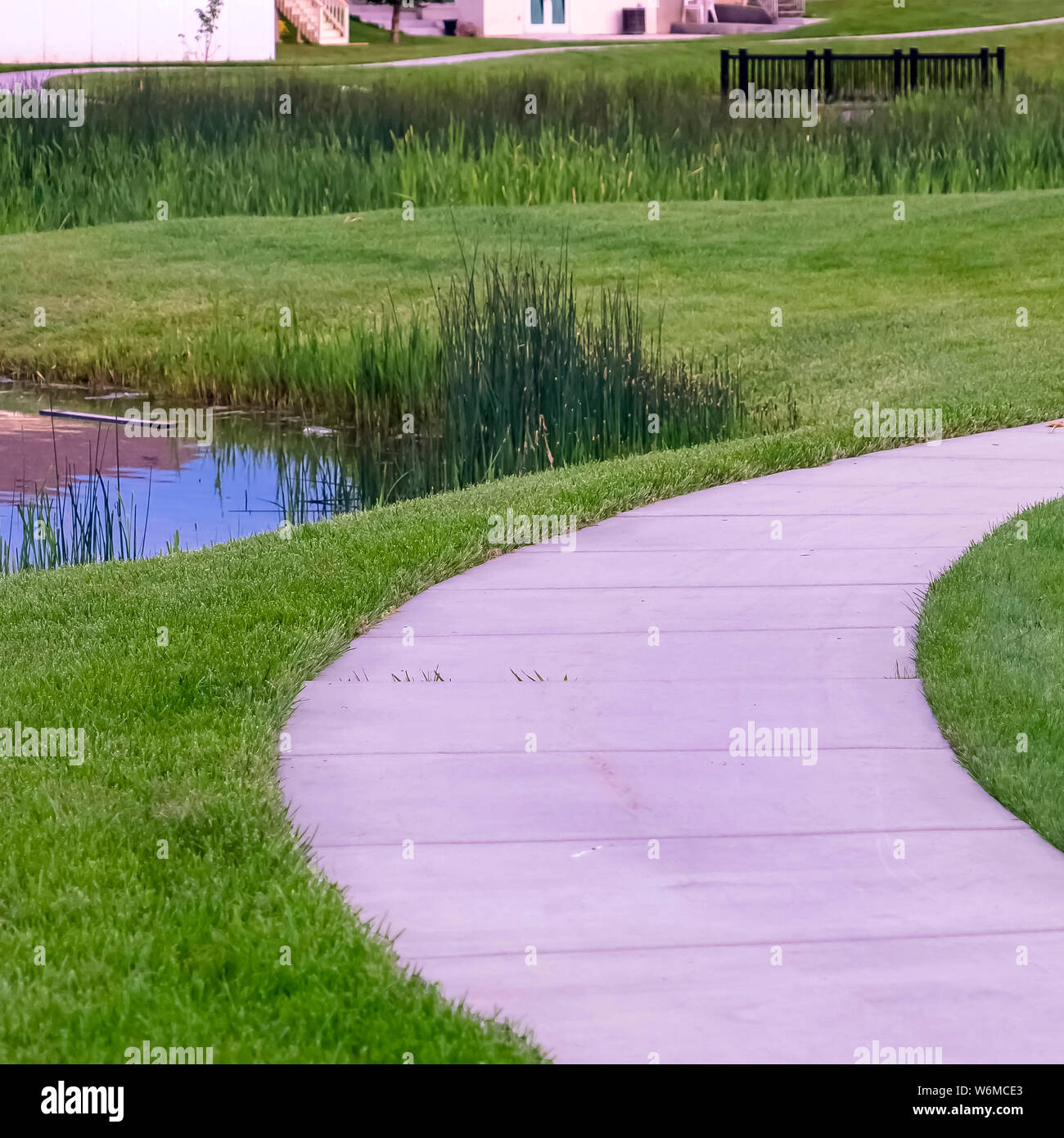 Square Close up of a pathway curving through a lush grassy terrain with ...