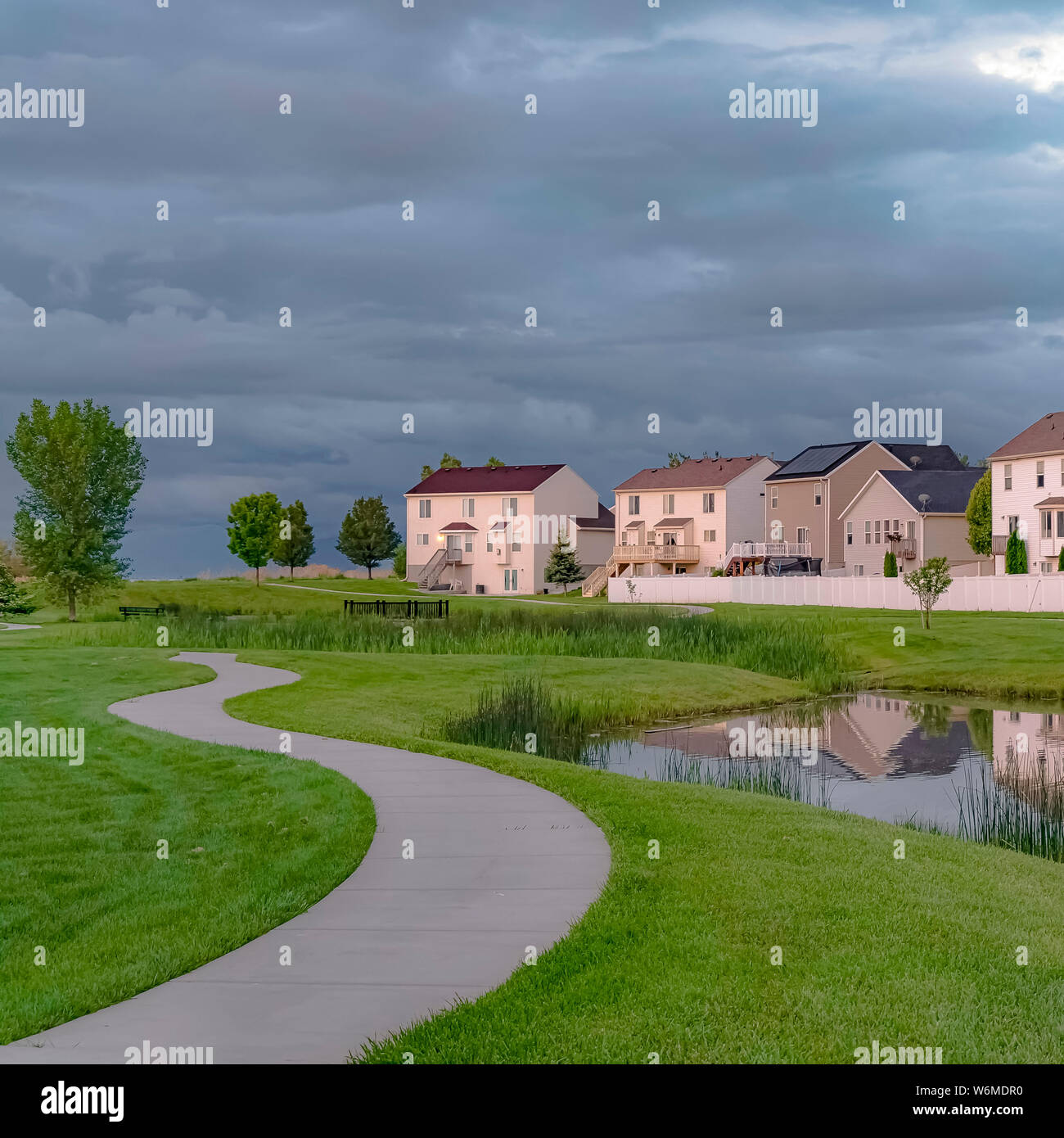 Square Park pathway and pond with bridge in front of houses with ...