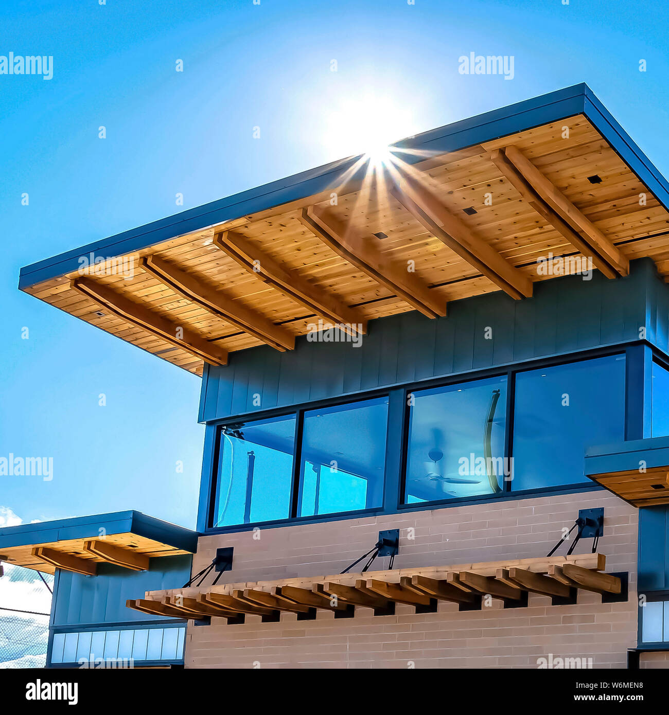 frame Facade of building with flat roof and brick wall against blue sky ...