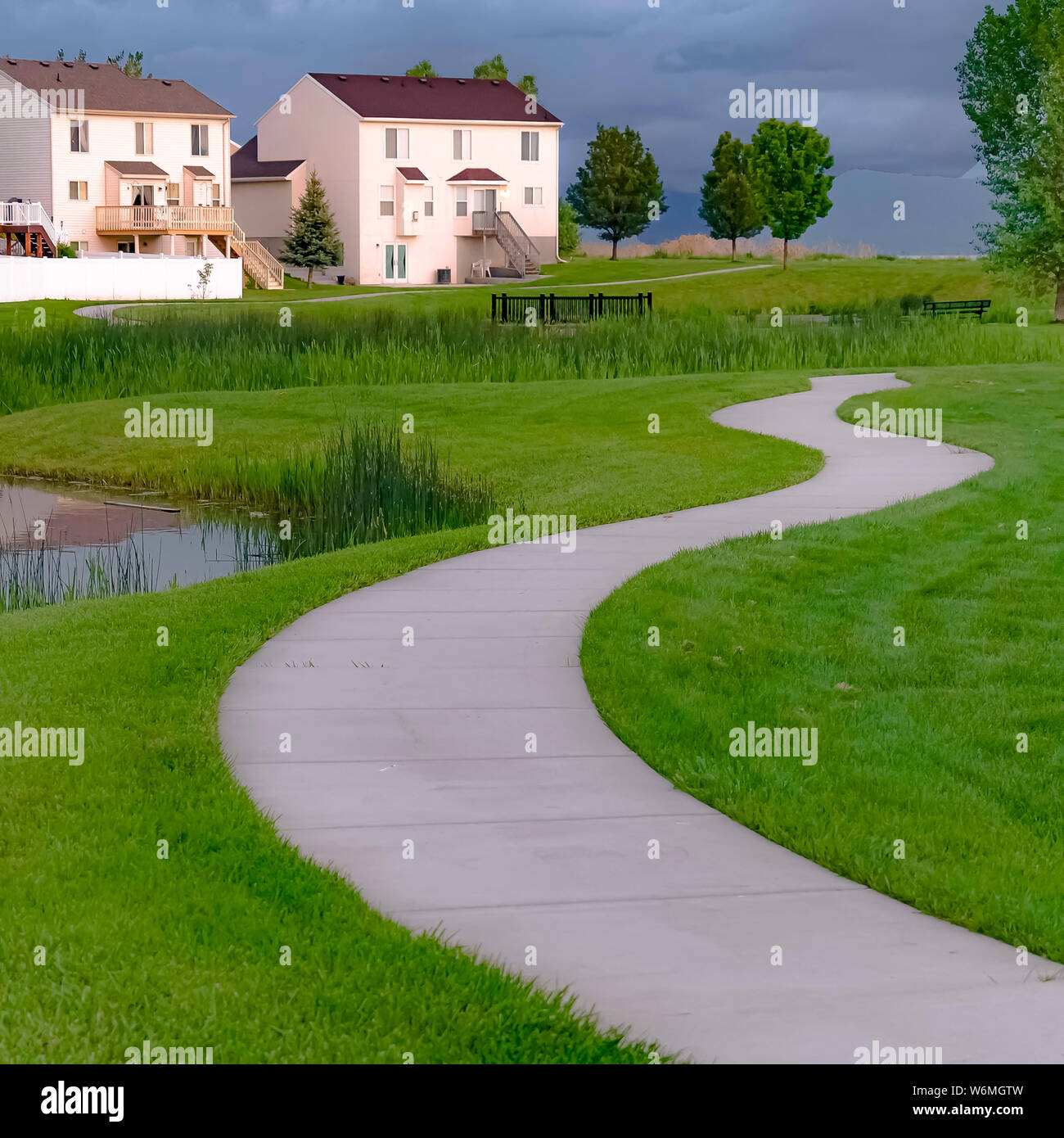Square Walkway and pond with bridge in front of homes with outdoor ...