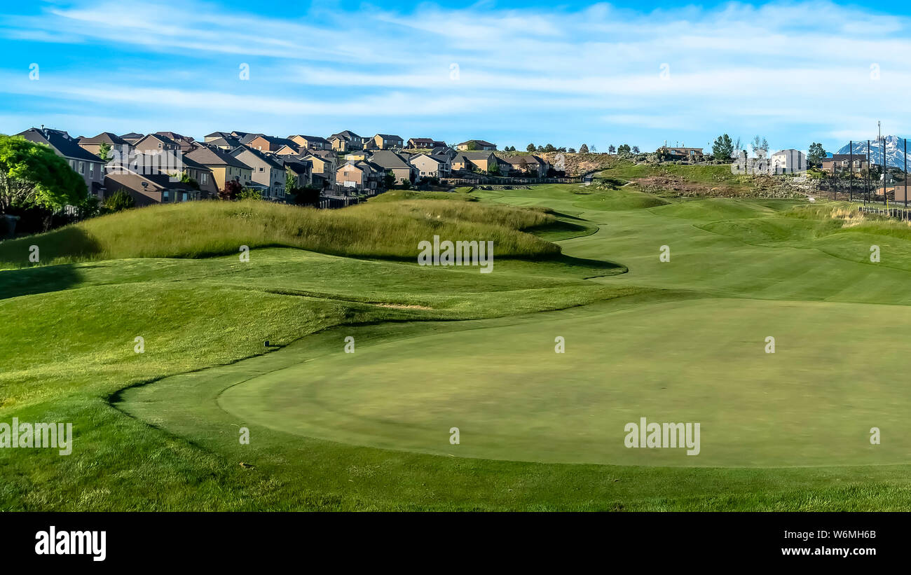 Panorama frame Golf course and homes under blue sky with clouds viewed ...