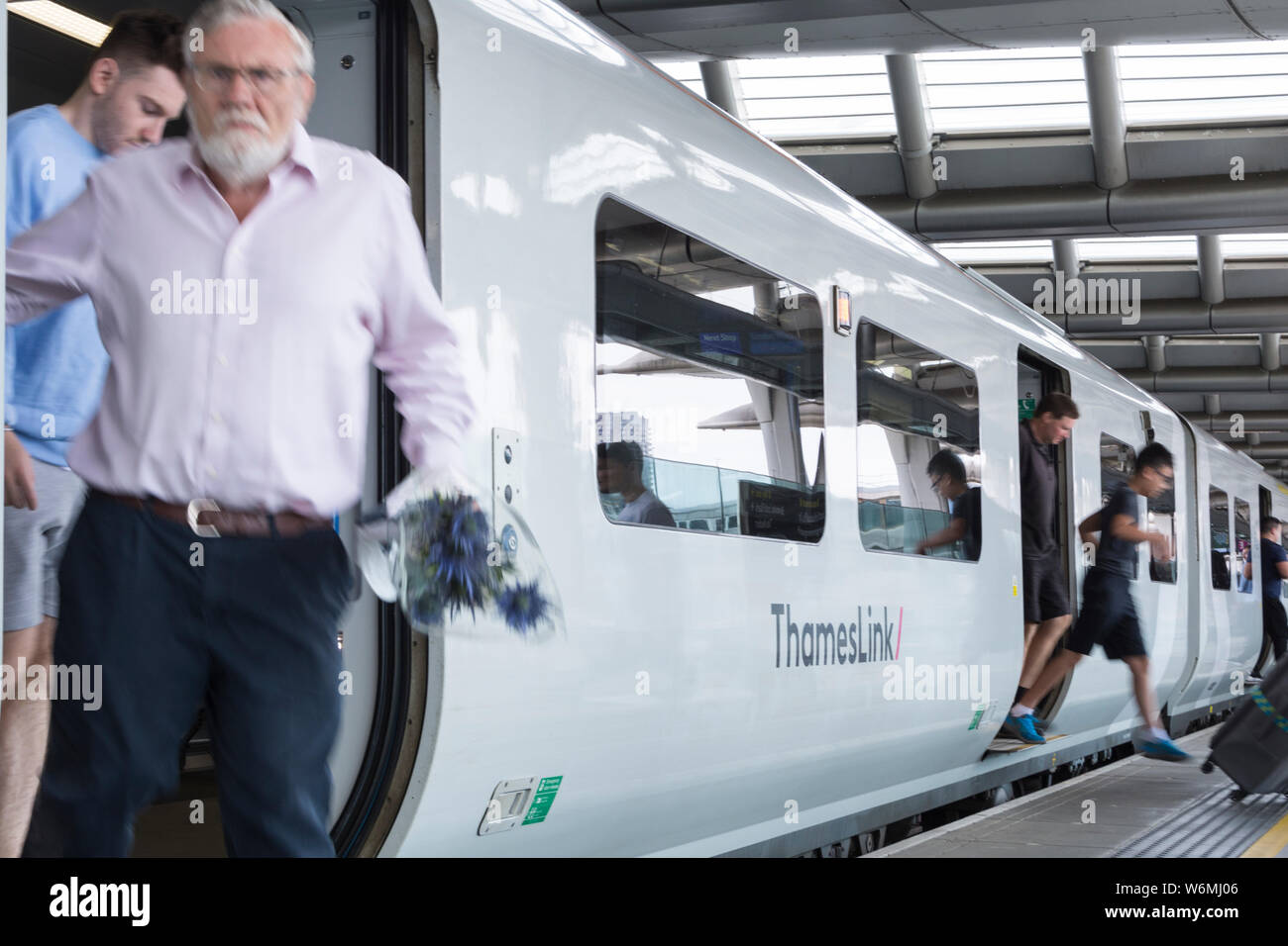 Close-up of passengers getting off a Network Rail ThamesLink train ...