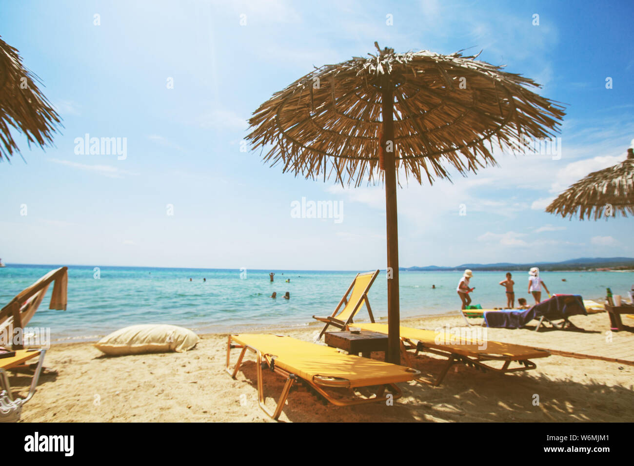 Summer holiday and travel concept - Sunbeds and sunshade on sand beach ...