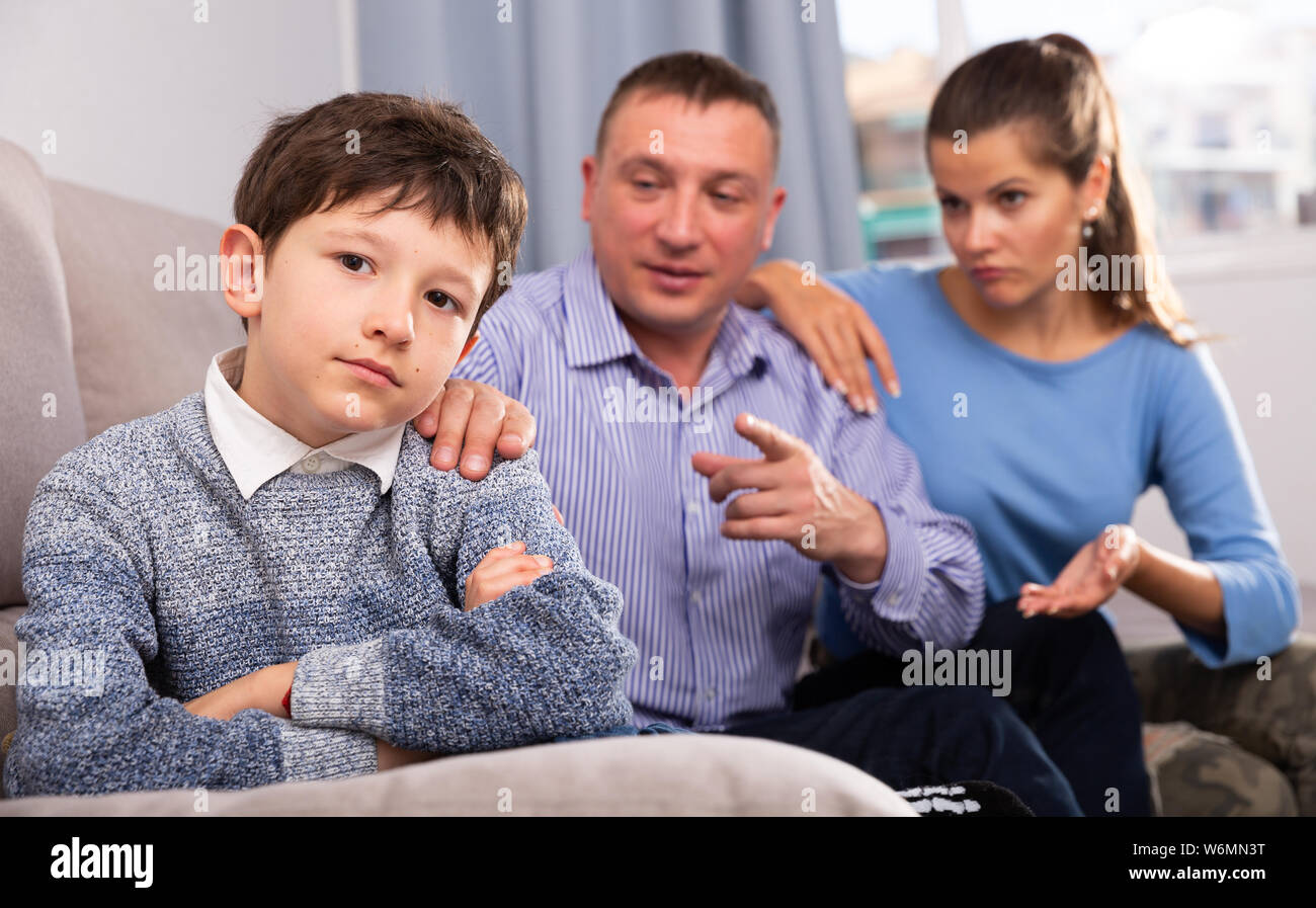 Portrait of upset boy scolded by parents at home Stock Photo - Alamy