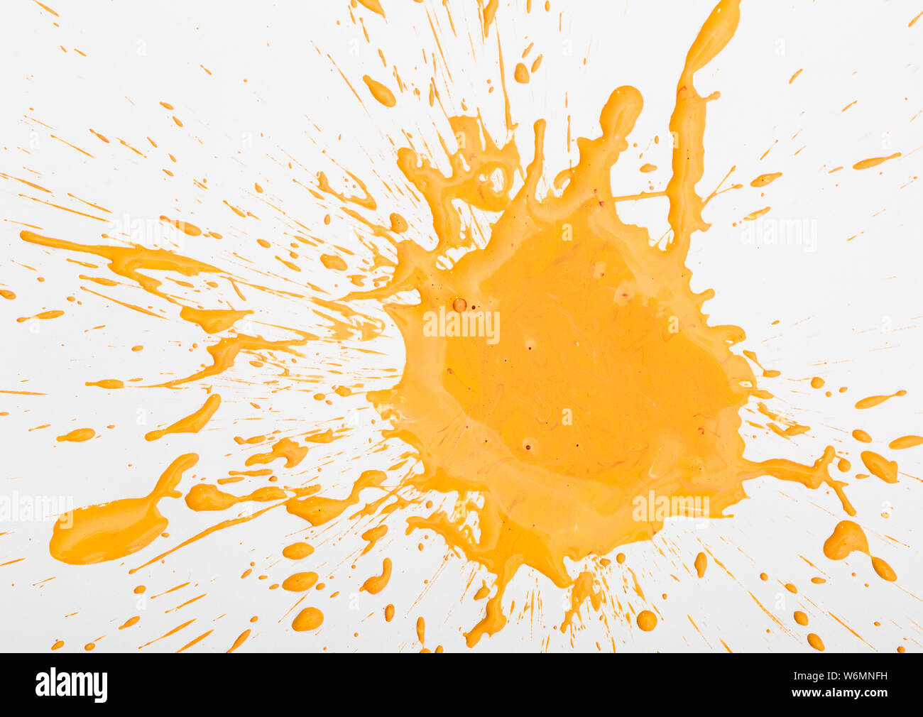 Spilled orange paint spots on paper, colorfull artistic image on white ...