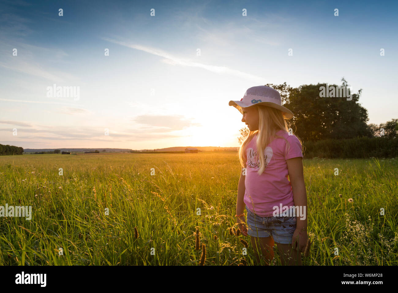 Happy girl enjoying the sunset at the countryside Stock Photo - Alamy