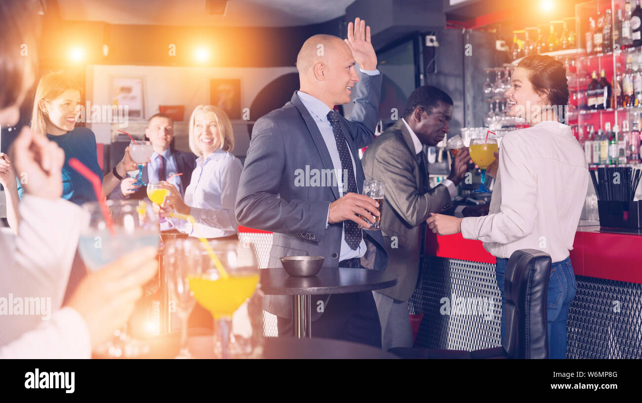 Cheerful positive smiling male and female colleagues having fun on ...