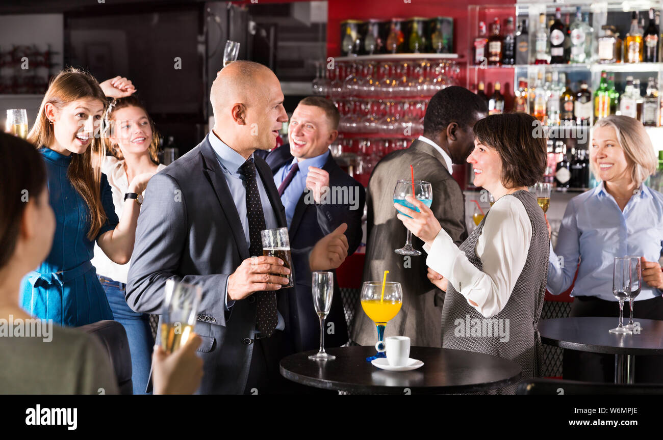 Portrait of man having a fun and talking to woman on corporate party ...