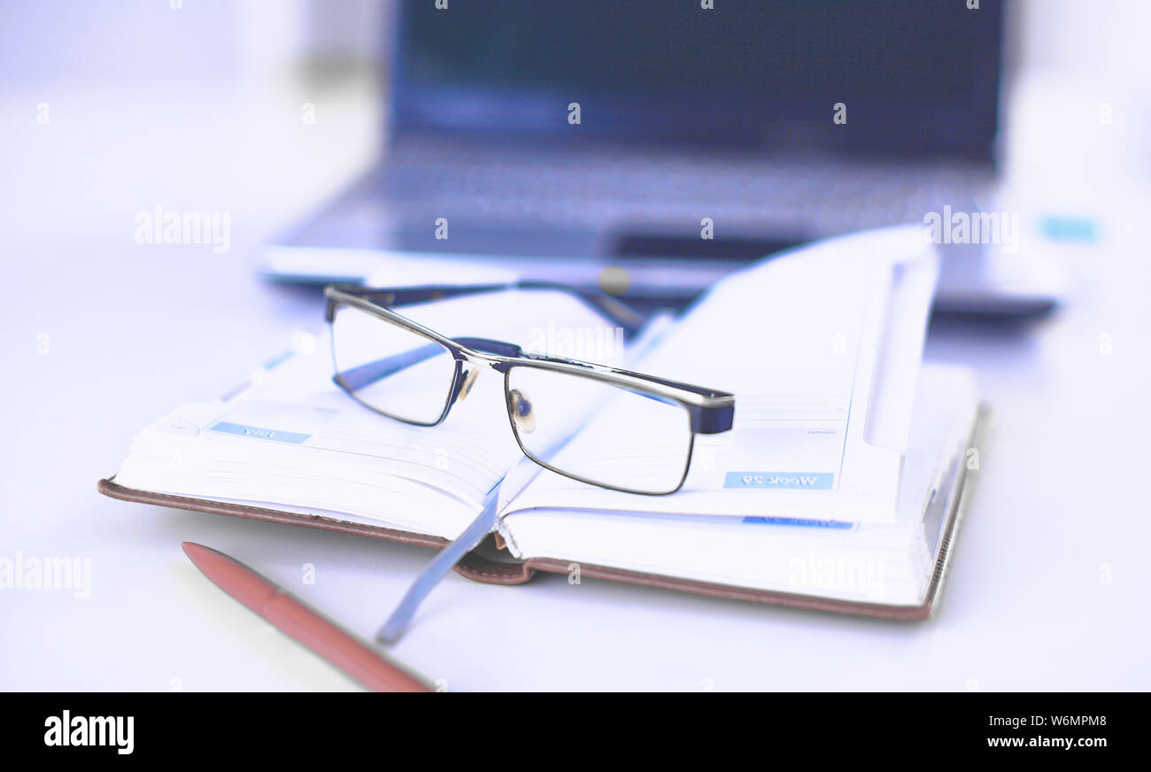 A note book, laptop, pen, graph paper document on the office desk table ...