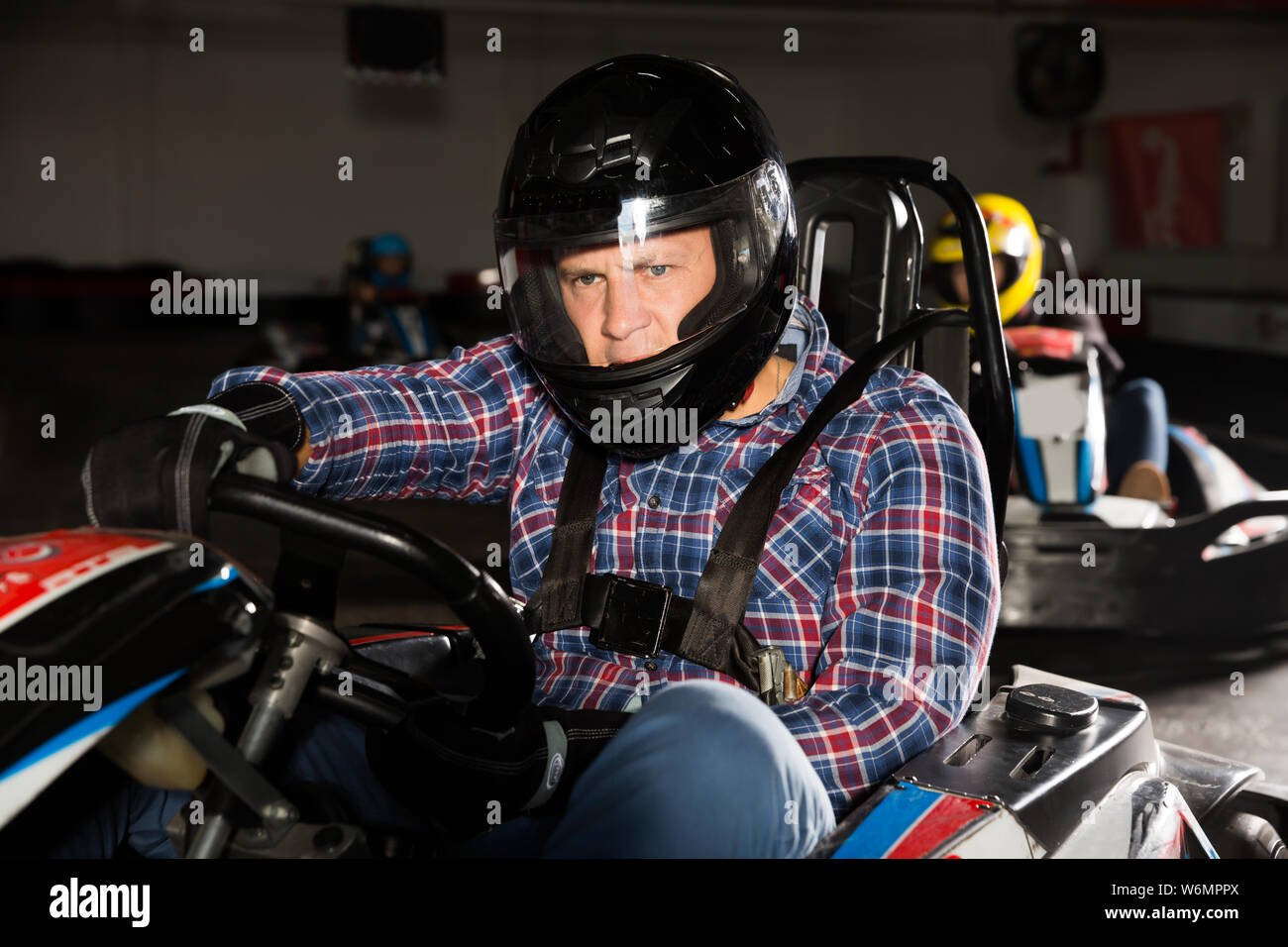 Portrait of happy man driving racing car at kart circuit Stock Photo ...