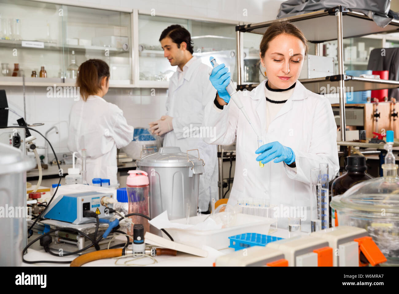 Diligent positive female student performing experiments in university ...
