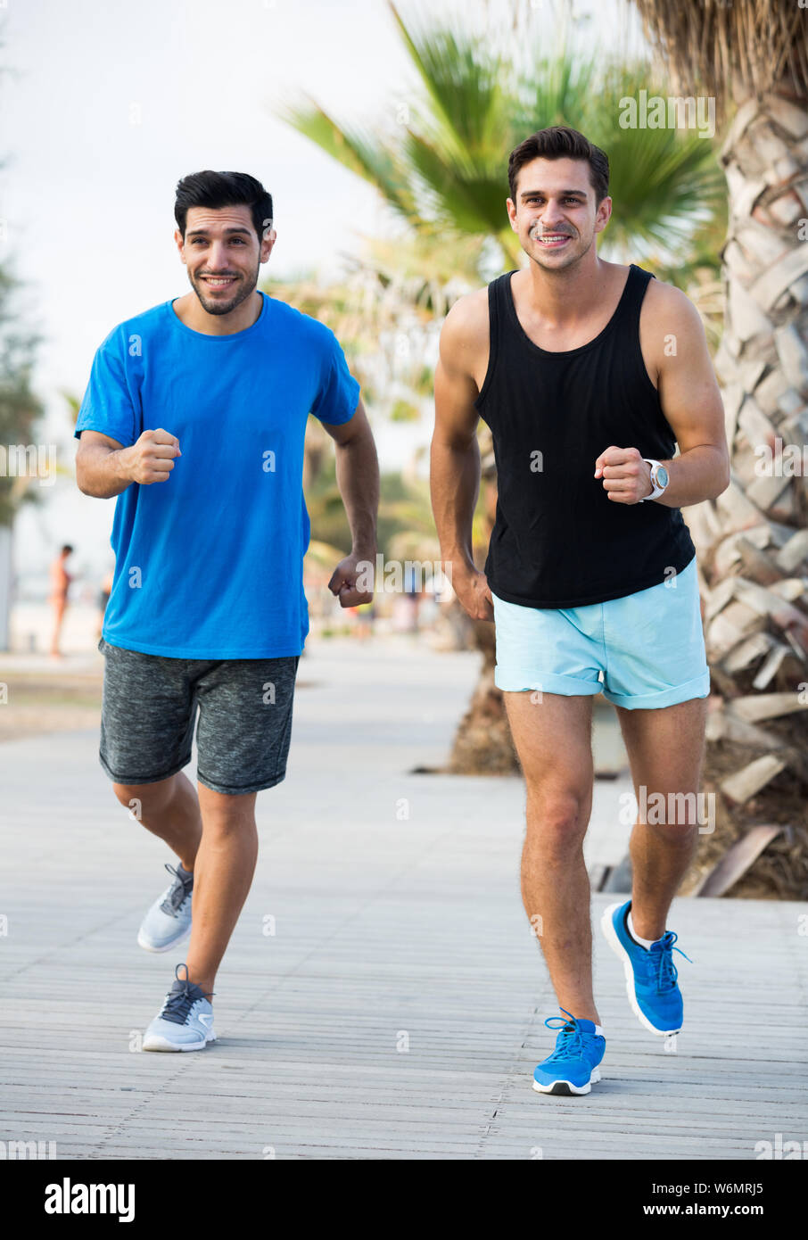 Adult men are jogging together in the park near ocean Stock Photo - Alamy