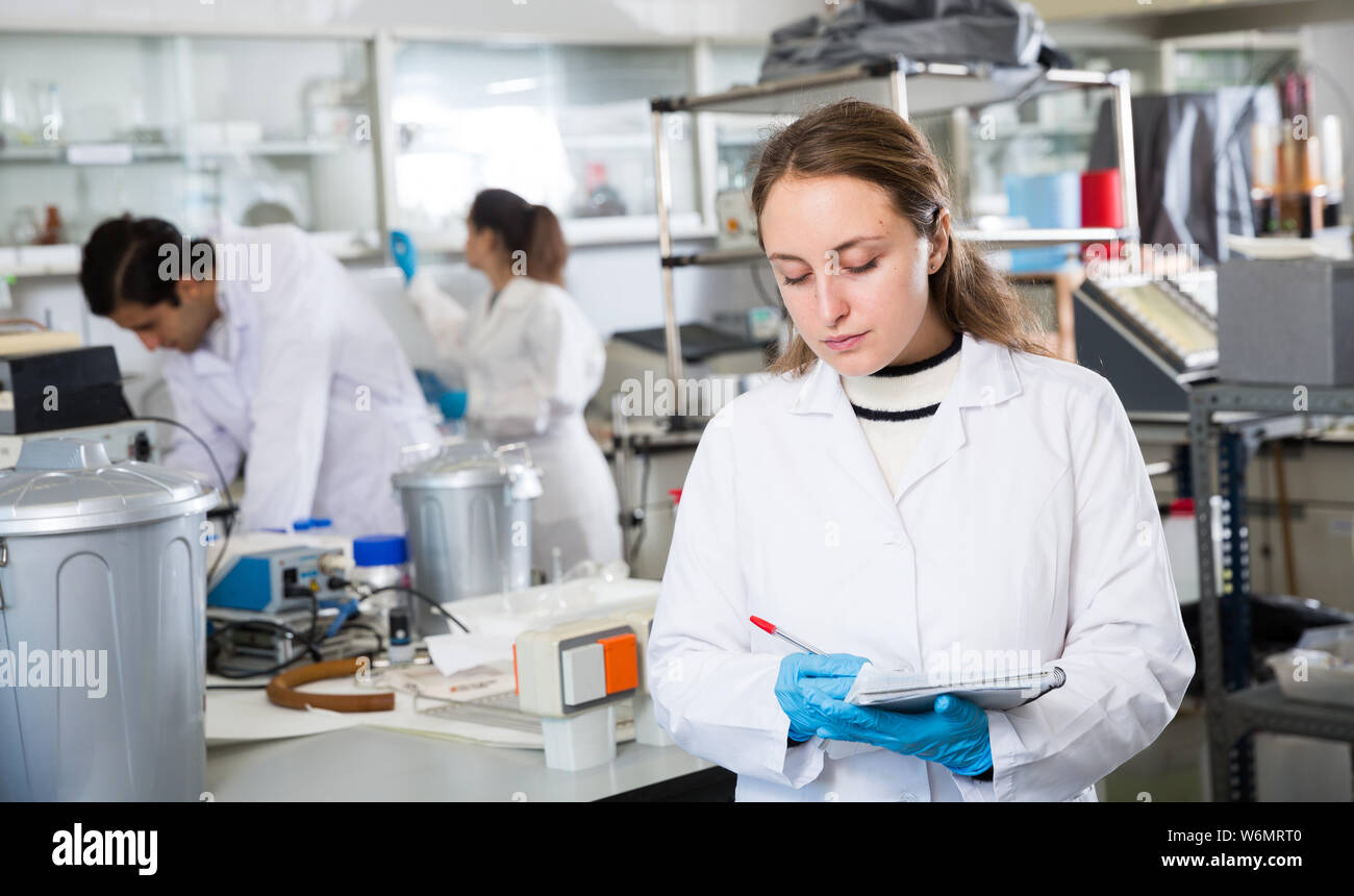 Young female scientist making research in chemical laboratory and ...