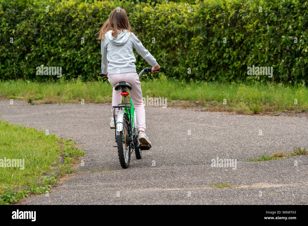 Rear view of a girl riding a bicycle Stock Photo - Alamy
