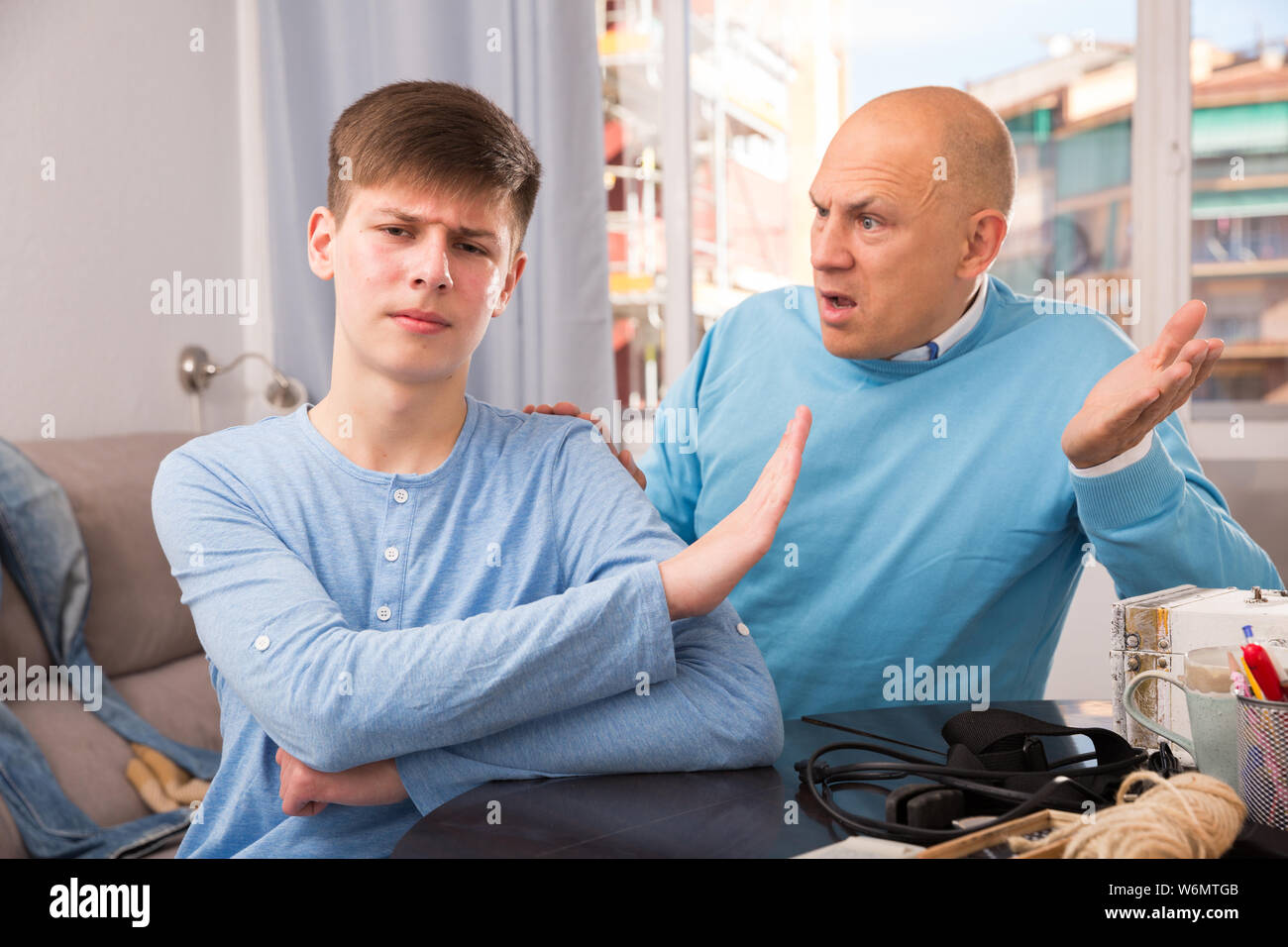 Teenage boy making stop gesture with his hand to scolding father Stock ...