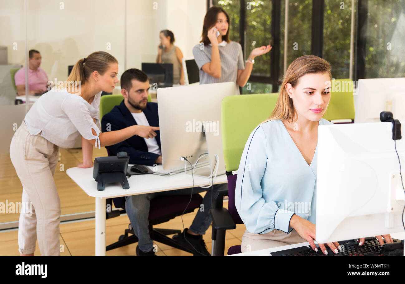 Successful coworkers engaged in business activities in busy open plan ...