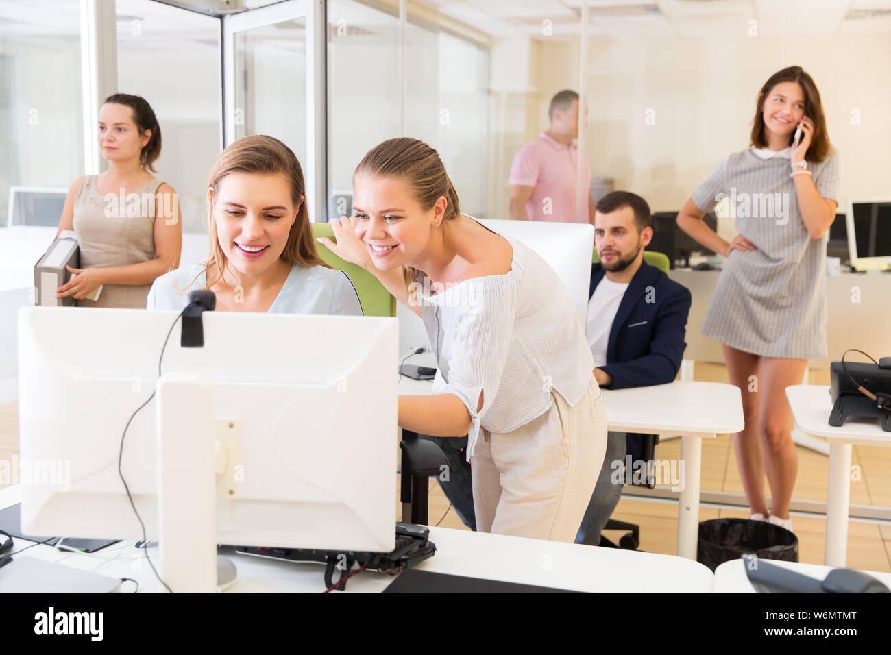 business woman explaining something to female coworker, pointing at ...