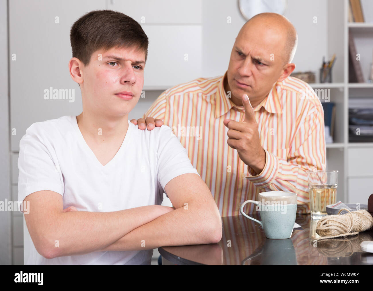 Unhappy man lecturing his teenage son at home interior Stock Photo - Alamy