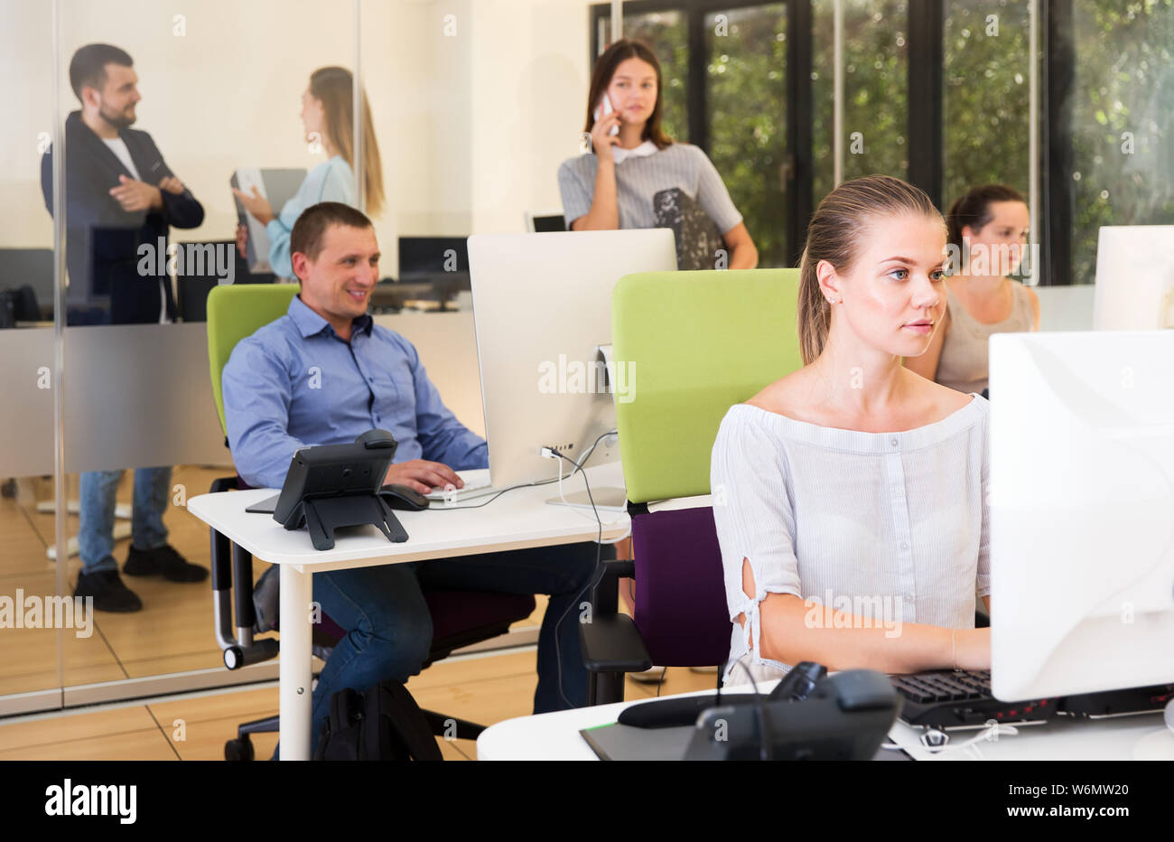Group of positive successful coworkers engaged in business activities ...