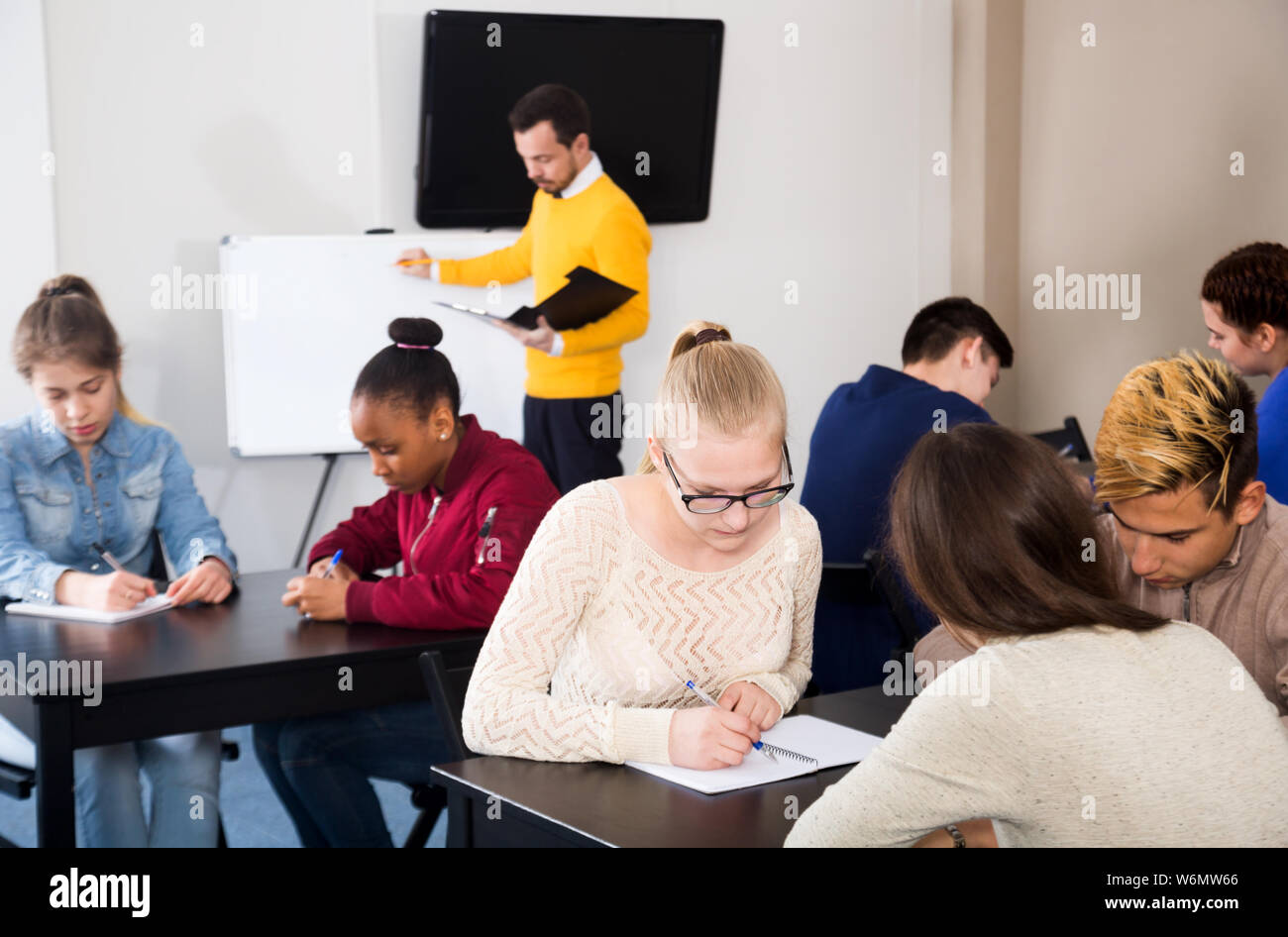 Happy classmates working in groups to complete task during class Stock ...