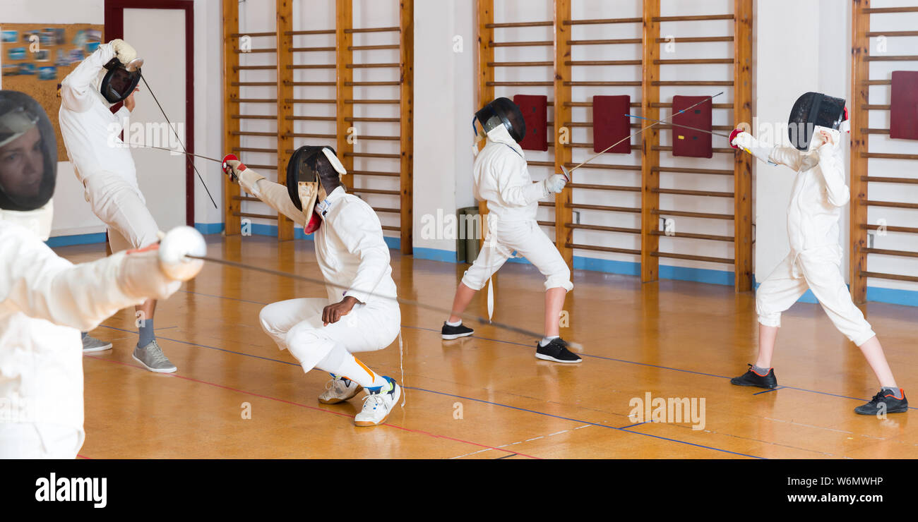 Friendly group practicing effective fencing techniques in sparring in ...
