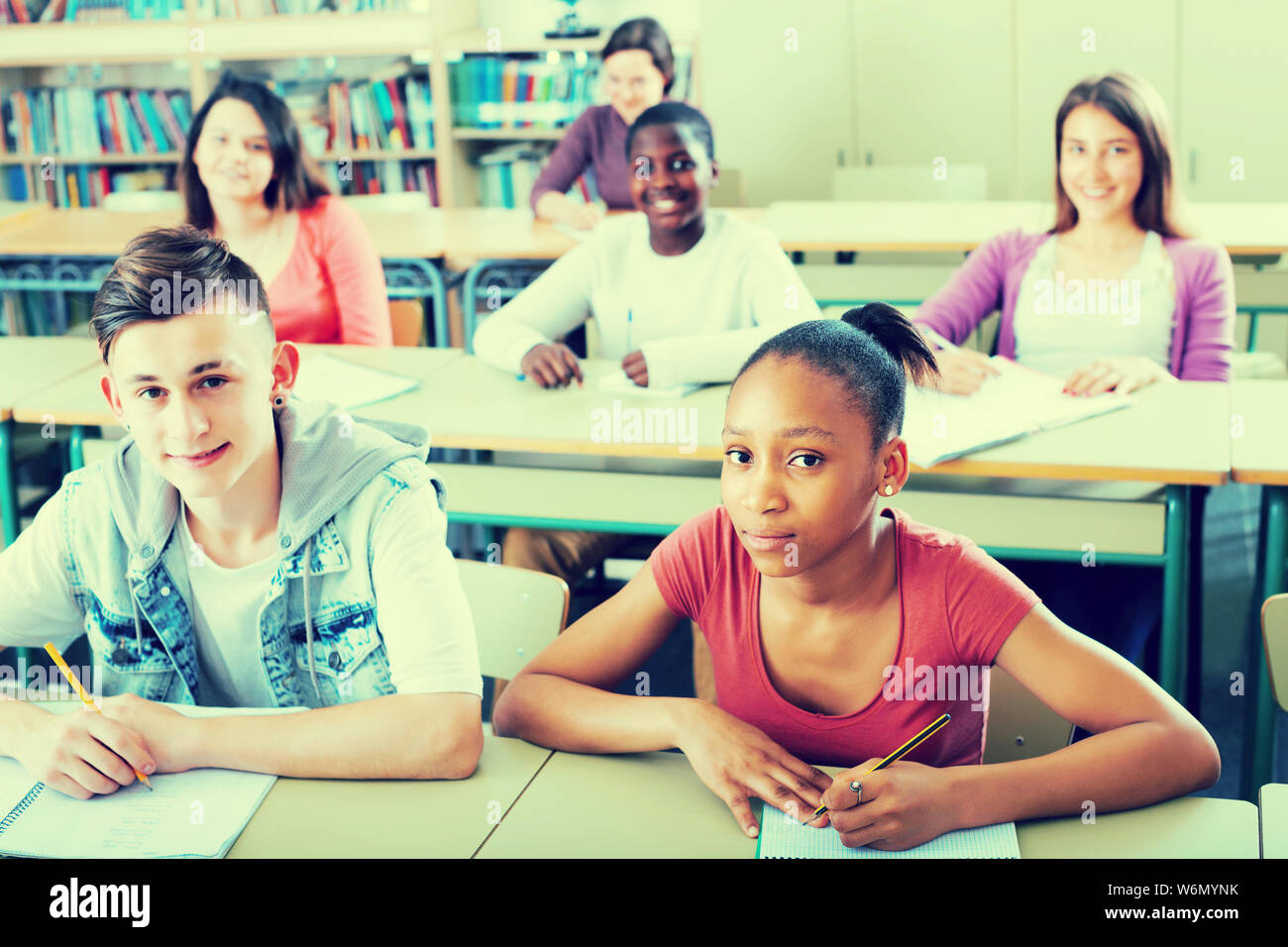 Young happy students studying together in the classroom Stock Photo - Alamy