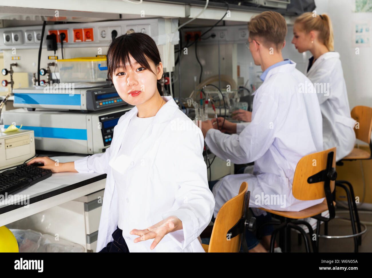 Portrait of intelligent Chinese girl student working with her ...