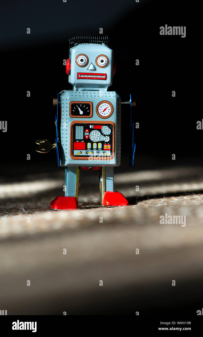 Vintage metal blue robot toy on sunlight. Futuristic concept with small ...