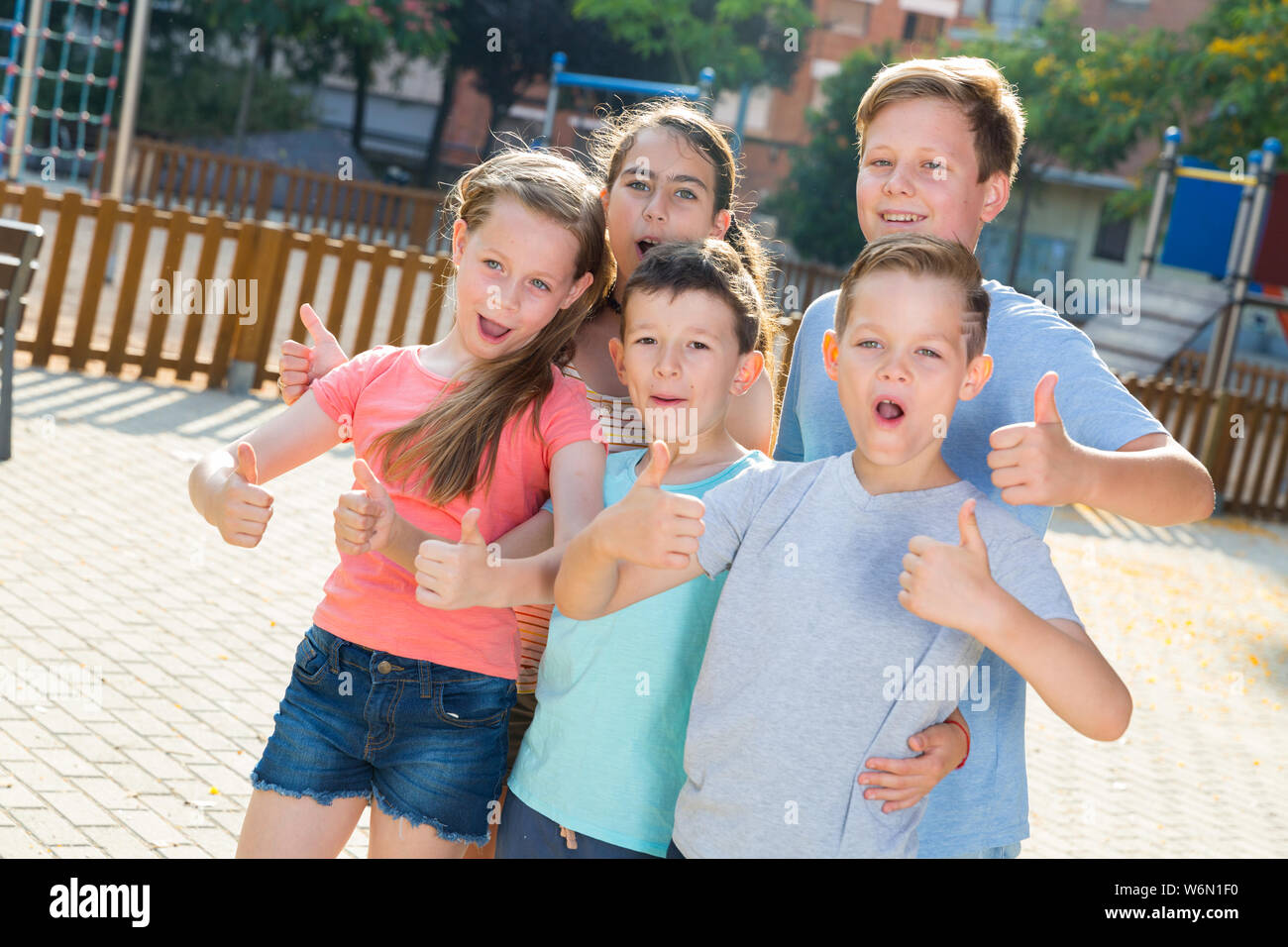 Glad kids posing at the playground together and thumbs up Stock Photo ...