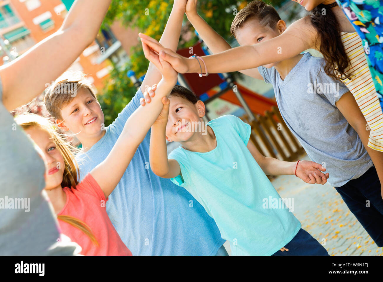 Group of cheerful positive smiling children playing at the playground ...