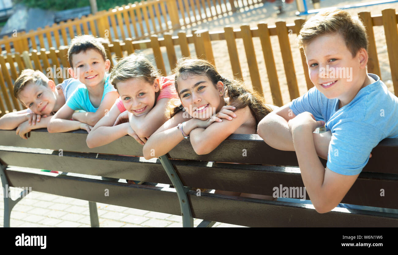 Five children sitting on a bench at the playground Stock Photo - Alamy