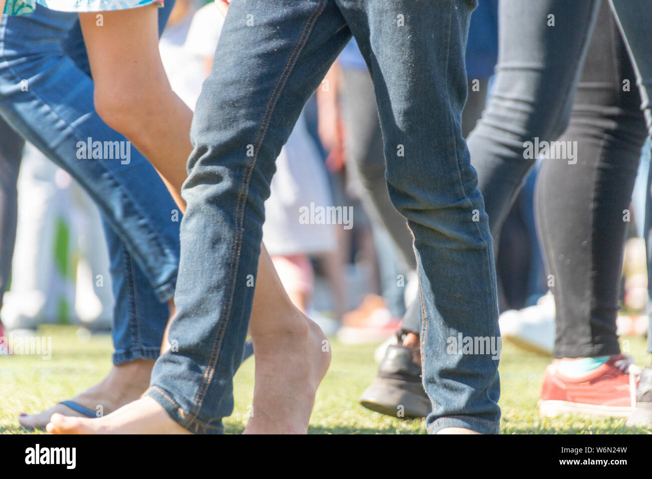 A close up view of the bottom half of peoples legs walking around a ...