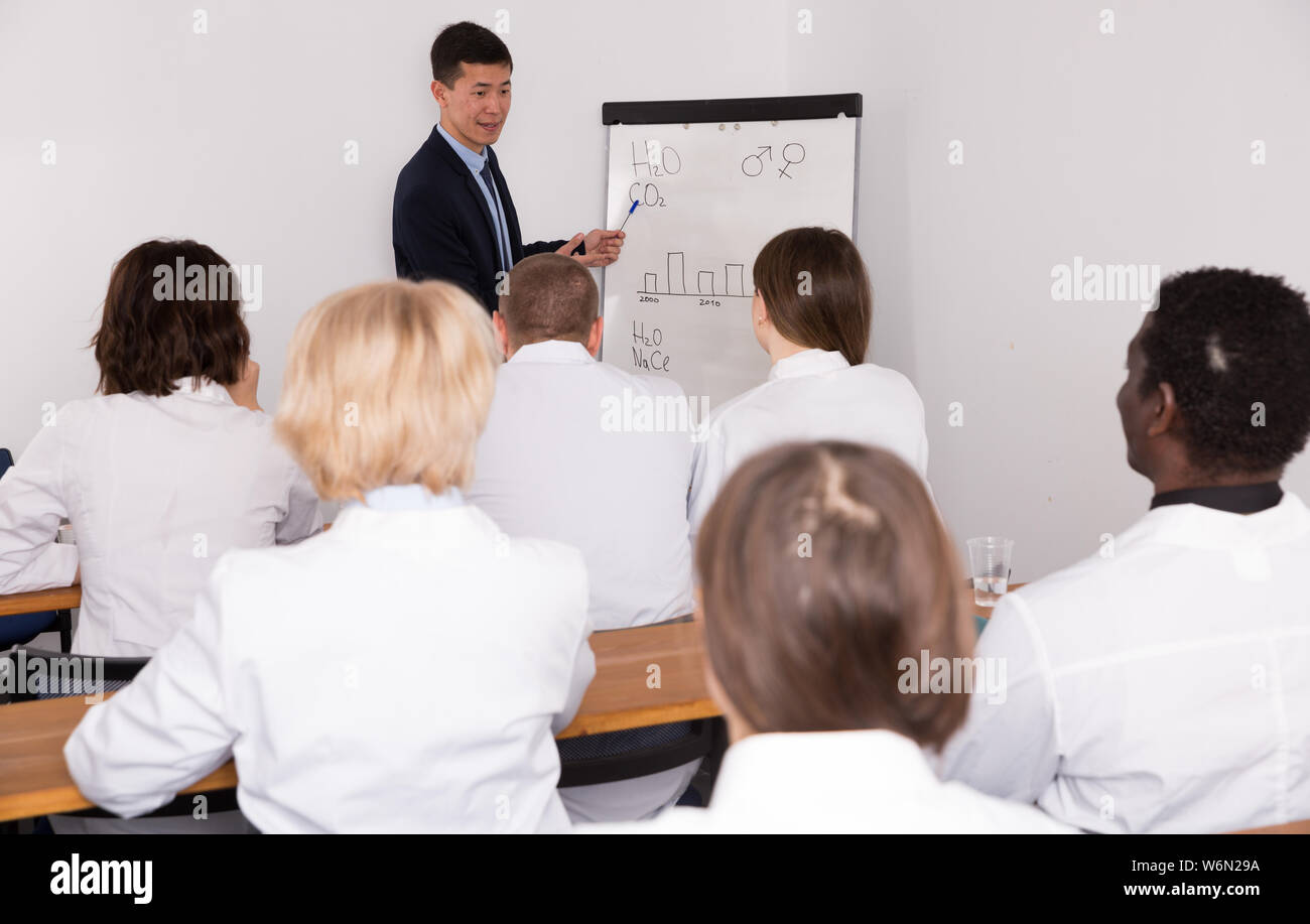 Smiling young male professor giving presentation for medics in ...
