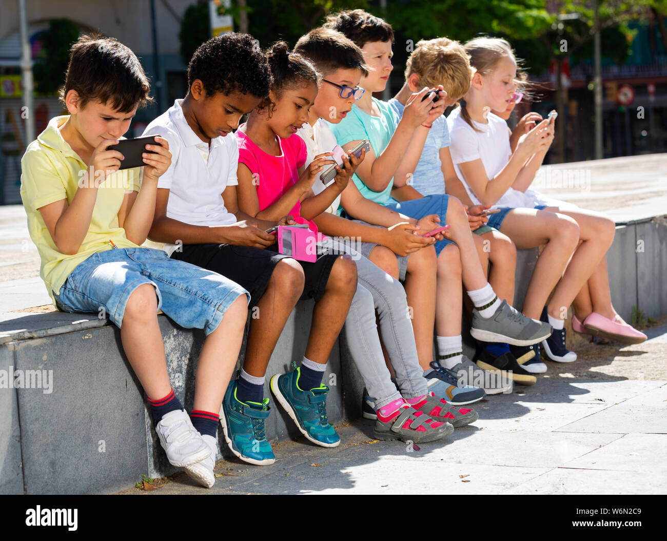 Children are playing on smartphone in the playground Stock Photo - Alamy