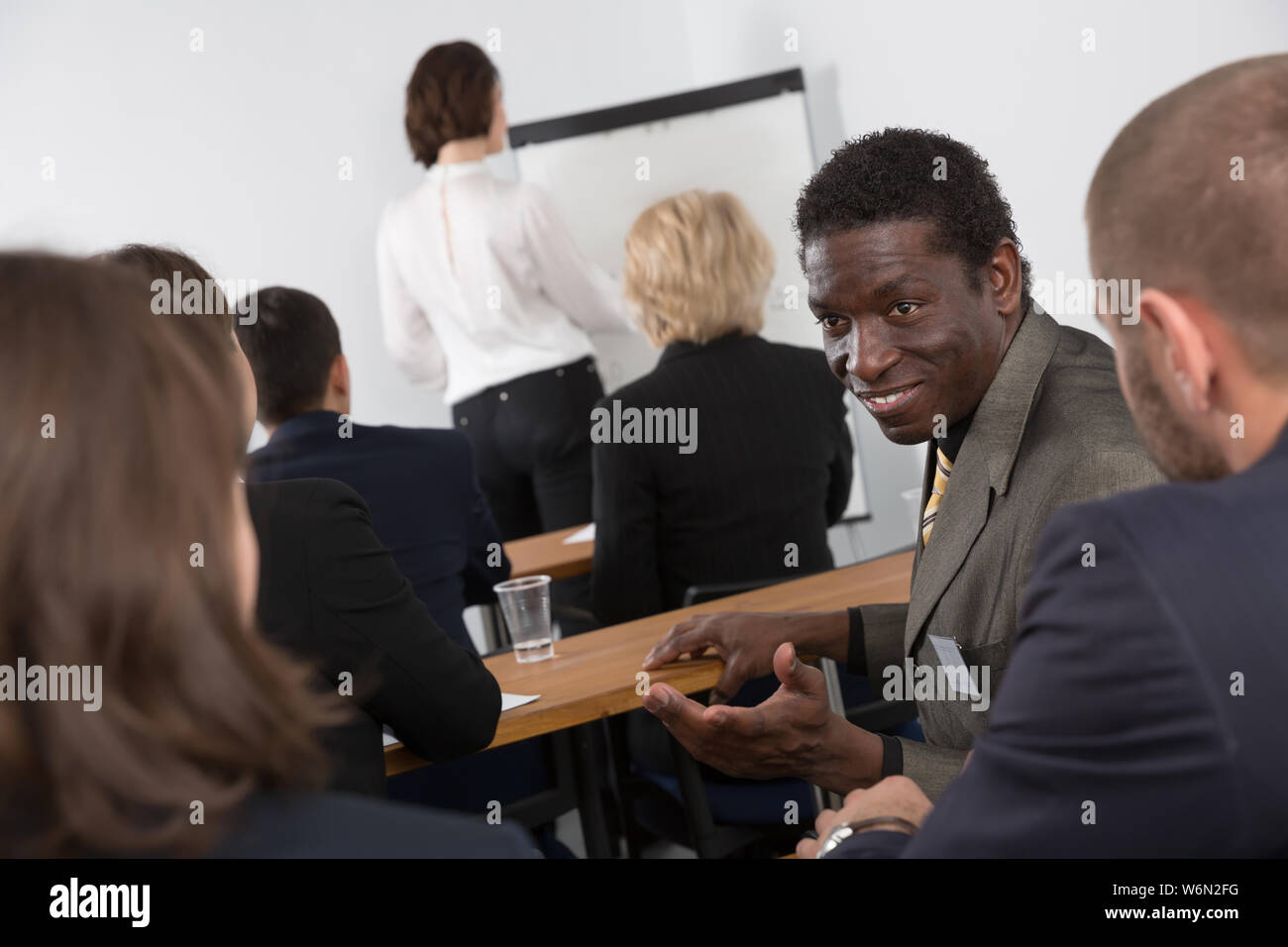African American business male talking with people during presentation ...