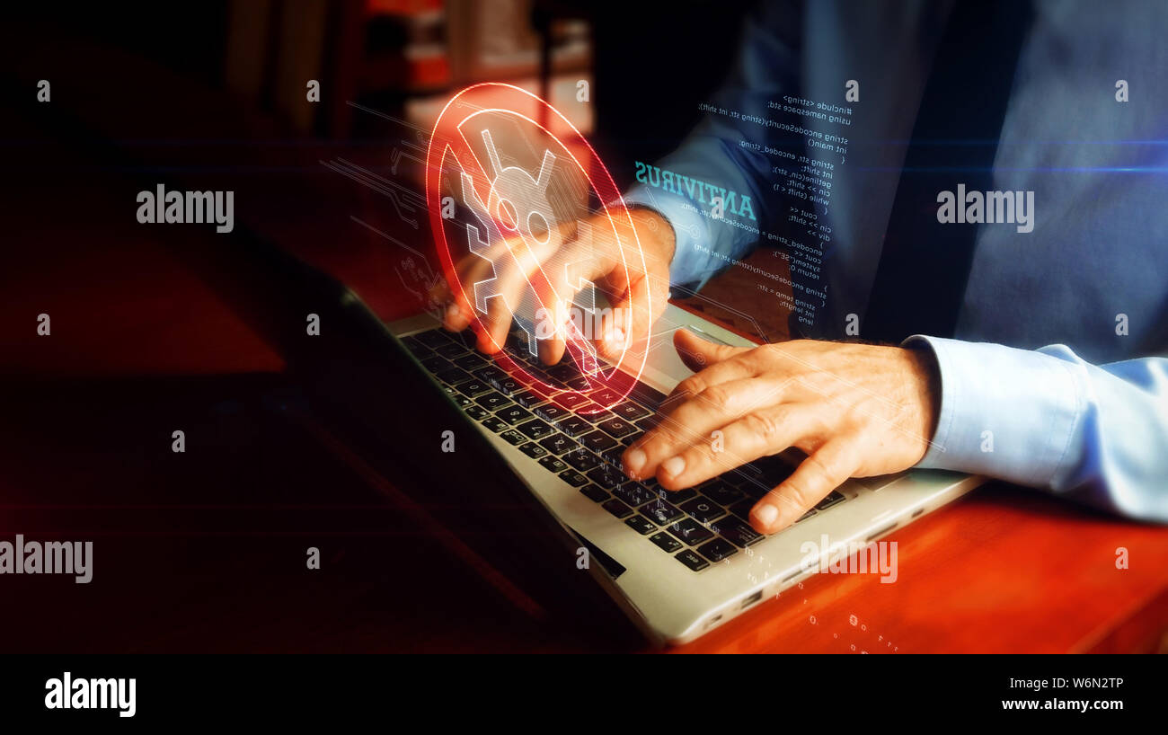 Man typing on laptop with antivirus hologram screen over keyboard ...