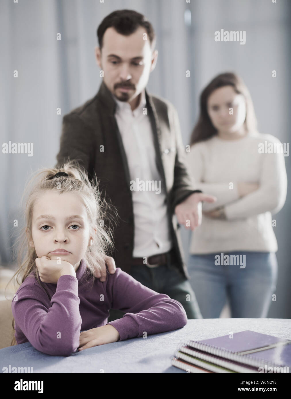 Ordinary parents lecturing their daughter for bad behavior at home ...