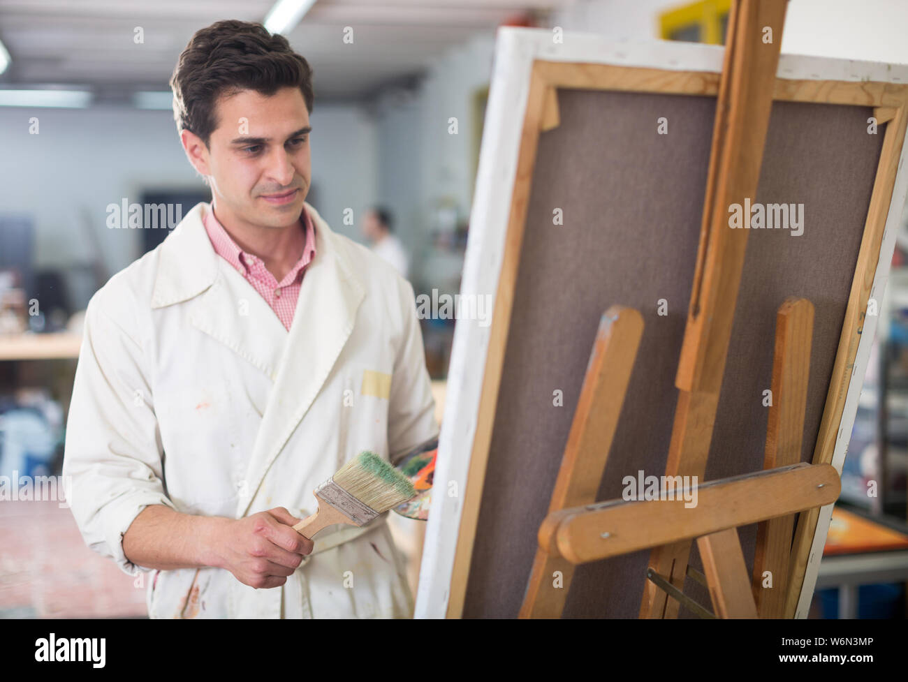 Creative male artist drawing picture with oil paints in studio Stock ...