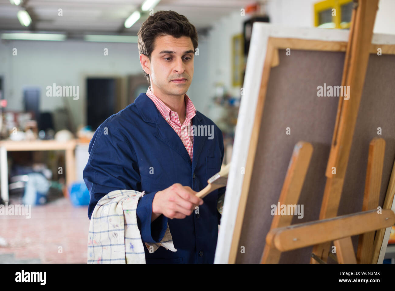 Happy art painter holding artist palette and painting on canvas Stock ...