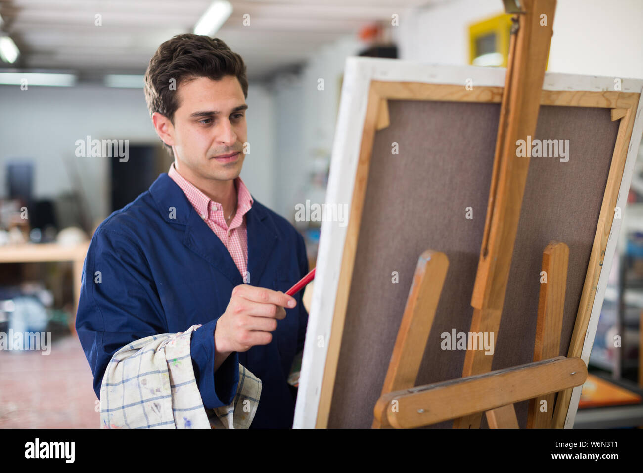 Happy art painter holding artist palette and painting on canvas Stock ...