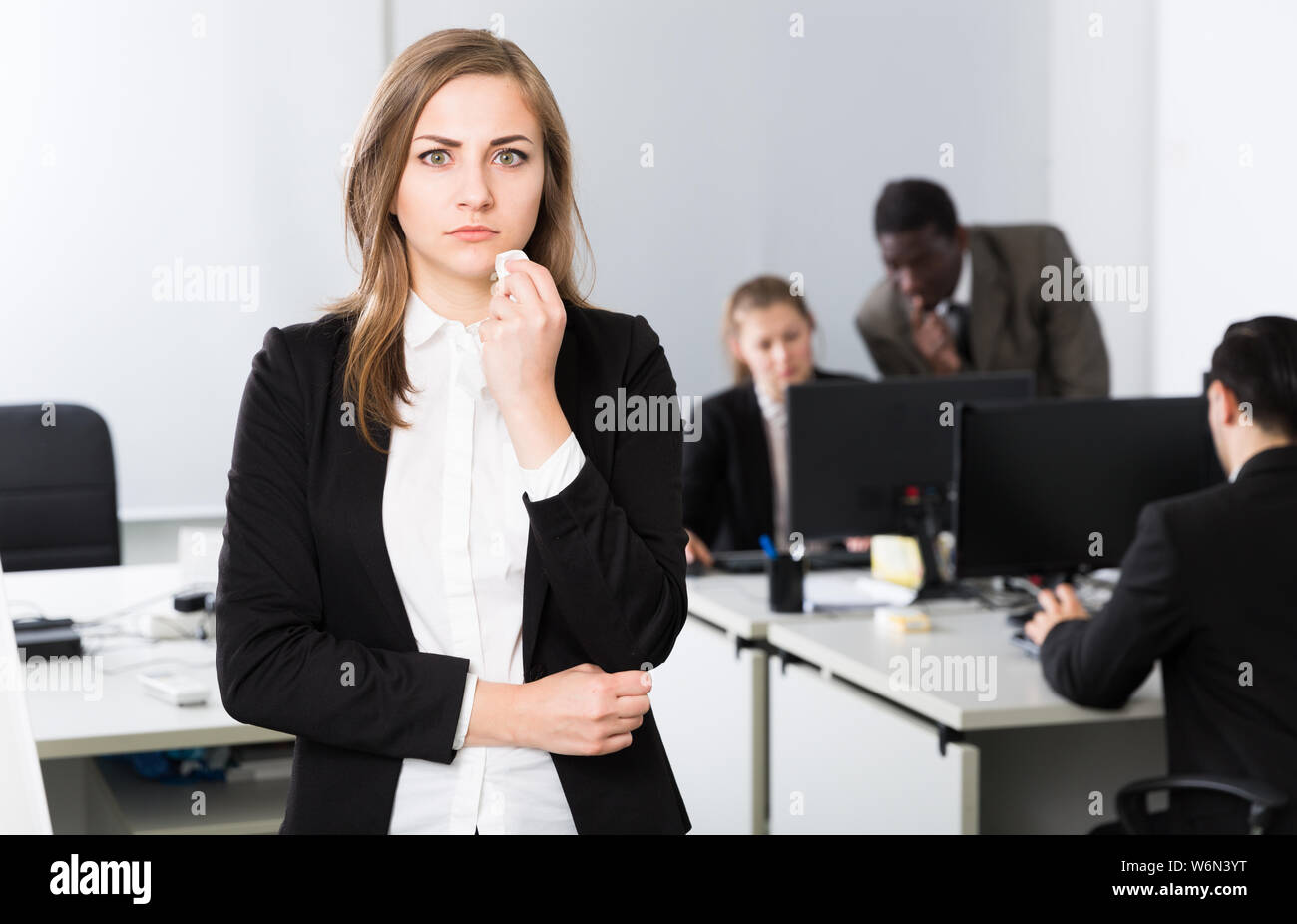 Unhappy and crying girl standing at modern open plan office on ...