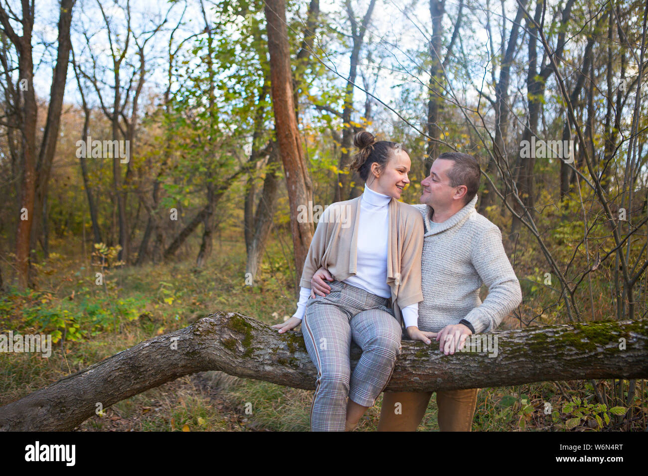 Beautiful couple sitting together on the tree in park hugging Stock ...