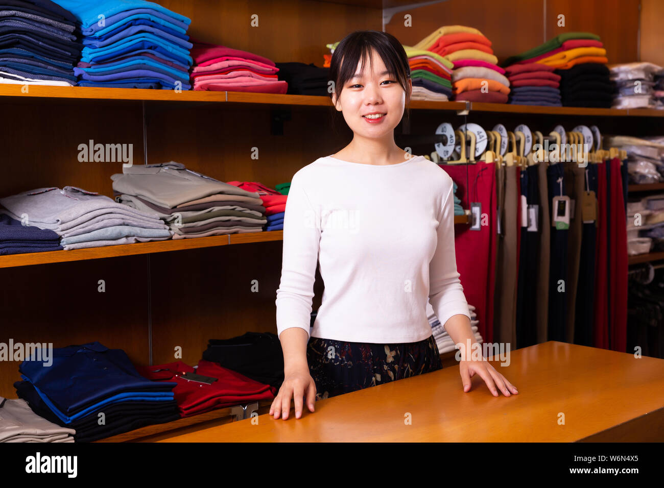 Chinese female shopping assistant offering various shirt in men’s ...