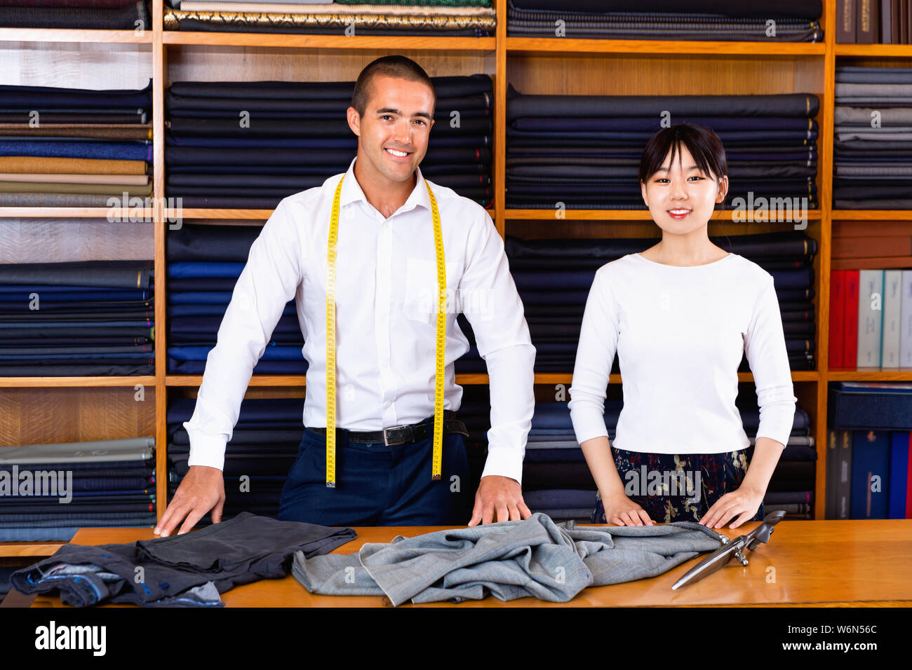 Portrait of confident cheerful positive smiling male tailor with young ...