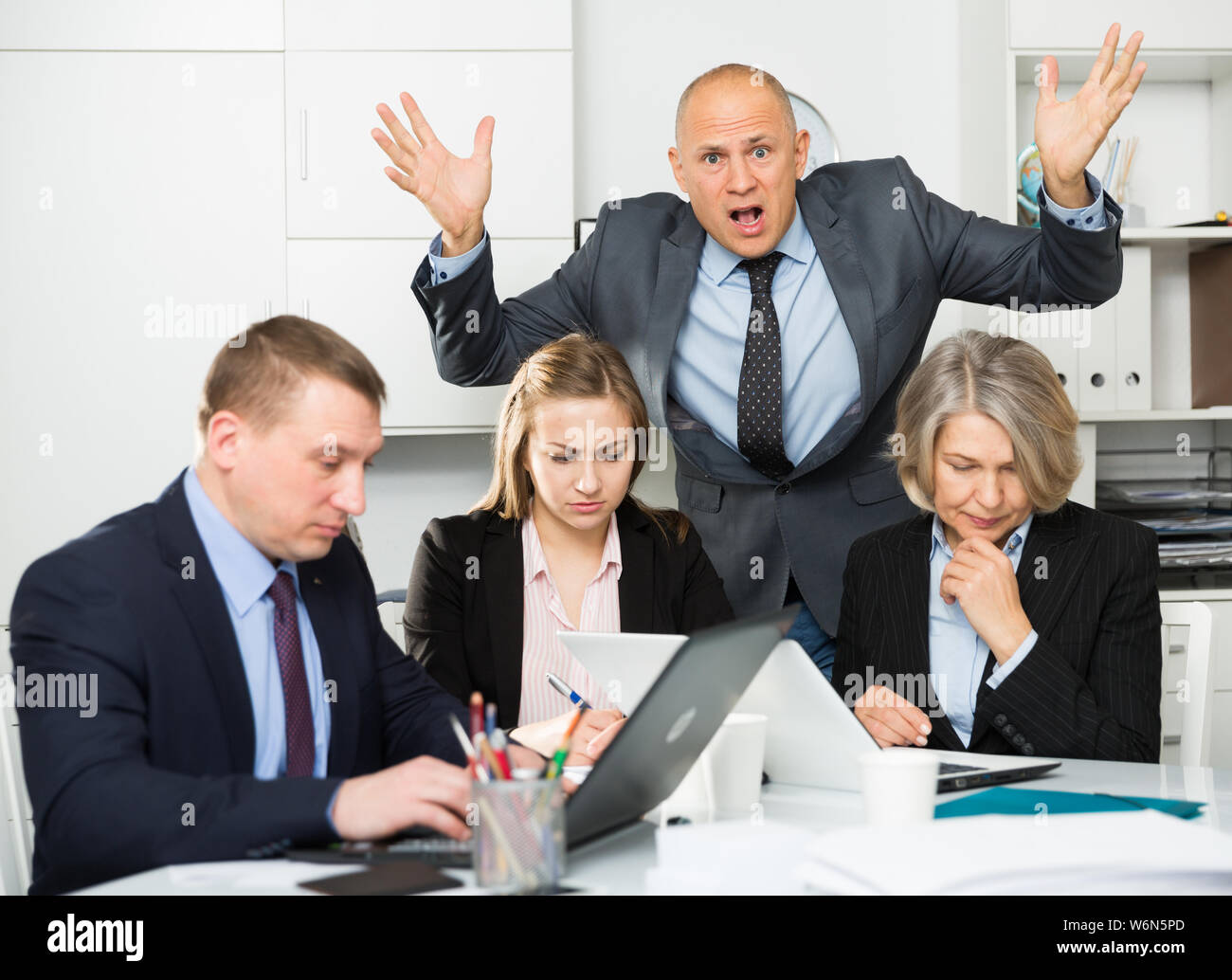 Businessman feeling angry to coworkers in office Stock Photo - Alamy