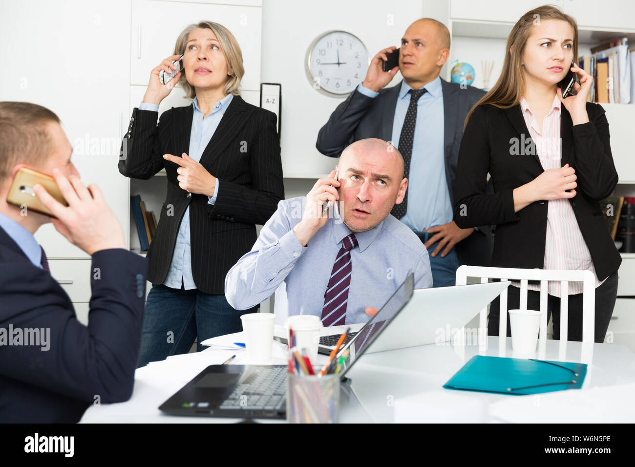 Portrait of confident team using mobile phones at modern office Stock Photo - Alamy