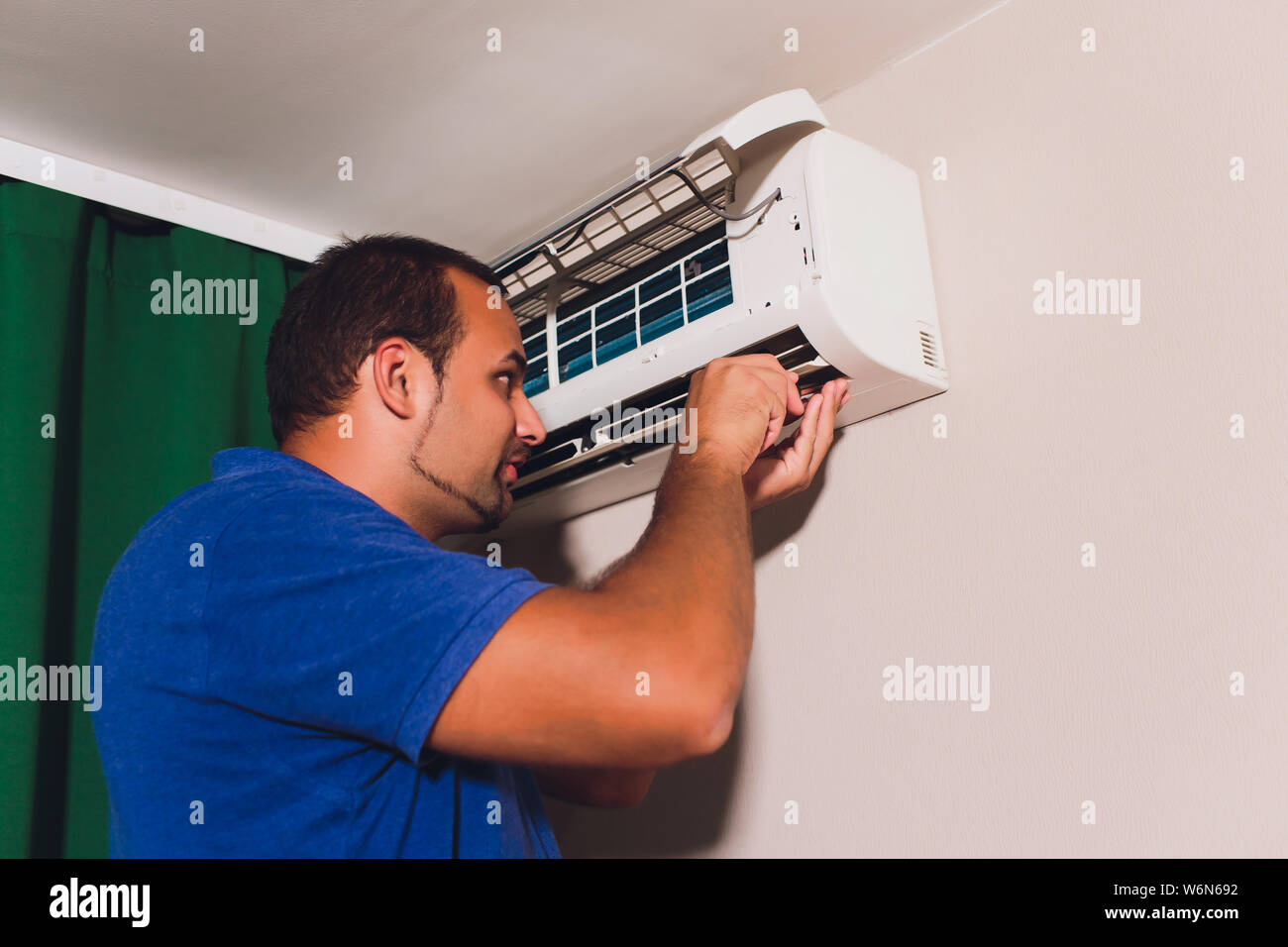 Male technician cleaning air conditioner indoors. service Stock Photo ...